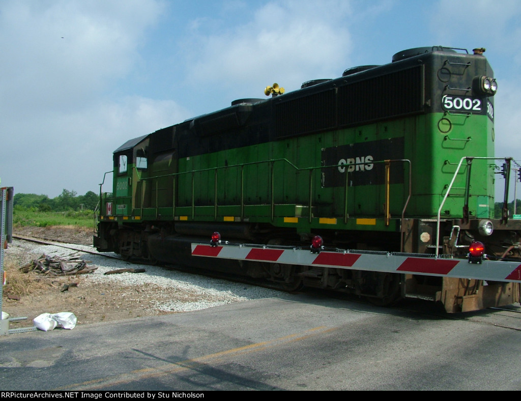 I&O (CBNS) 5002 rolls past grade crossing